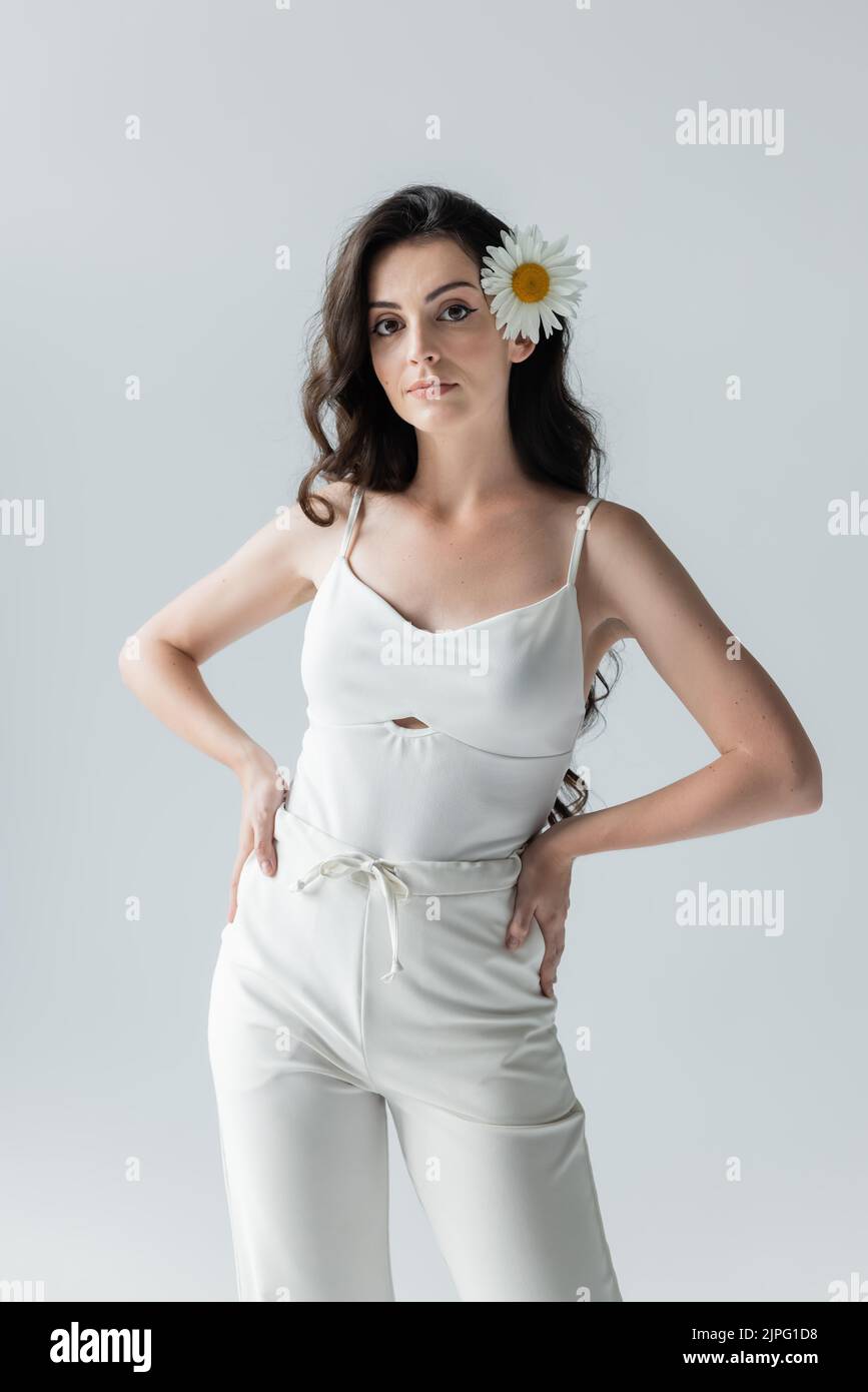 Woman in white clothes and with chamomile in hair standing isolated on ...