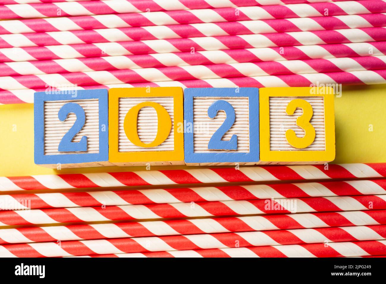 The wooden cubes with numbers showing 2023 between colorful striped ...