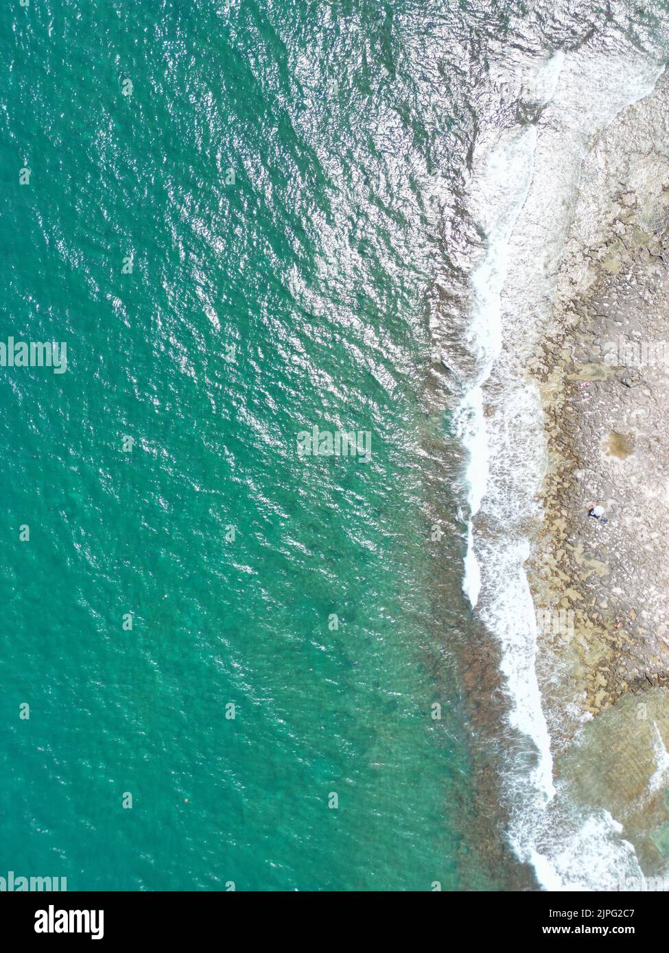 The vertical top view of the blue ocean waves reaching the shore Stock ...