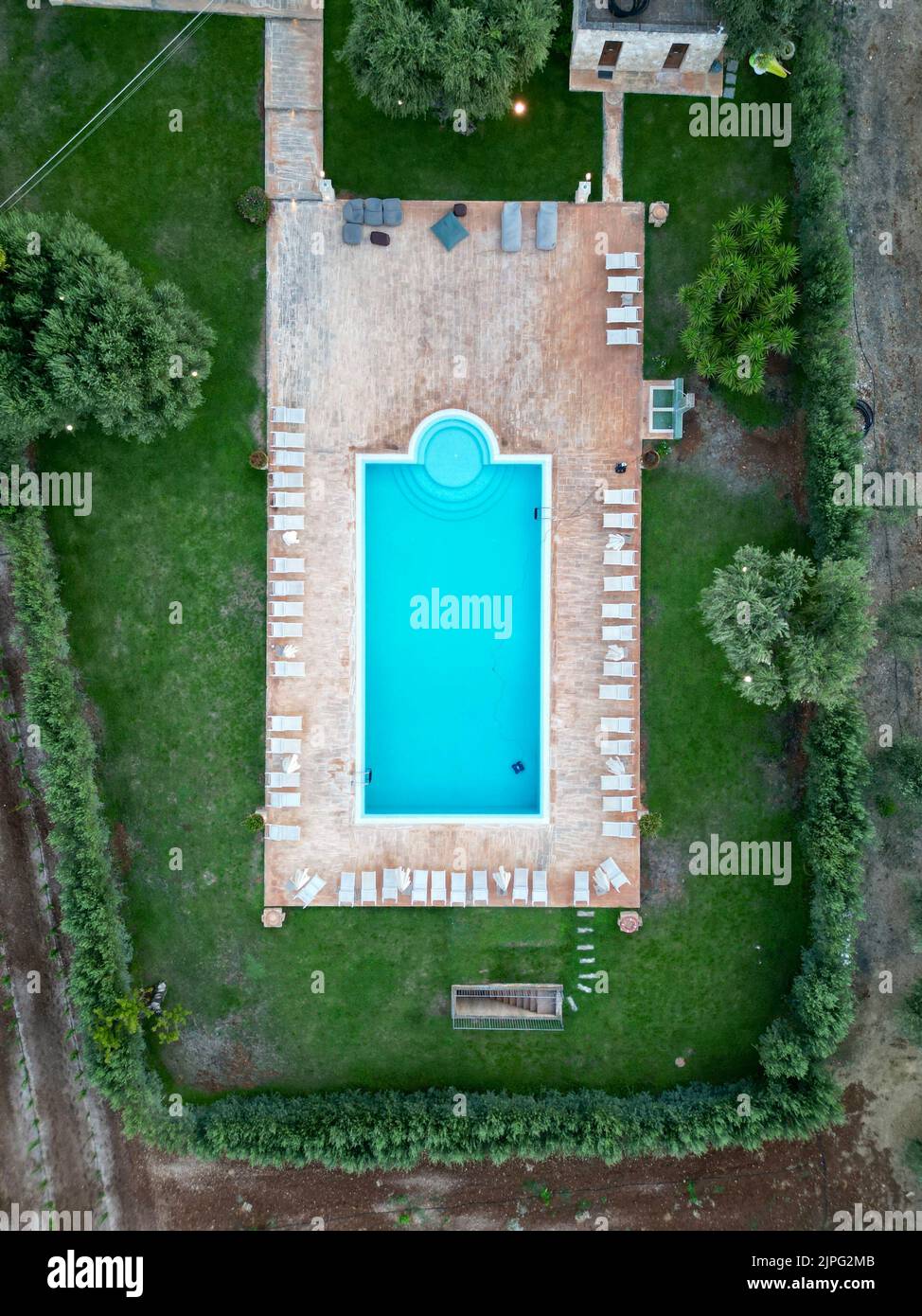 The vertical top view of a blue public swimming pool on a sunny day ...