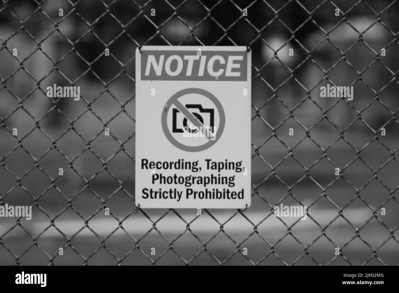 A grayscale closeup of a prohibition notice on a metal fence. Oahu ...