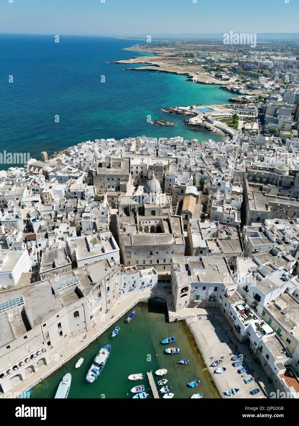 The vertical aerial view of a waterside city buildings on a sunny day ...