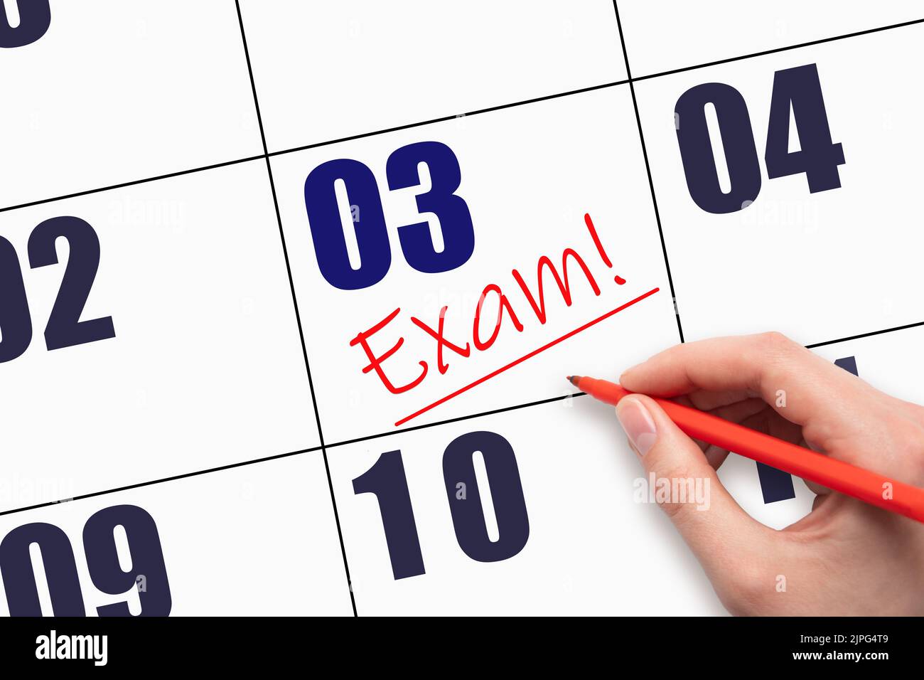 3rd day of the month. Hand writing text EXAM and drawing a line on ...