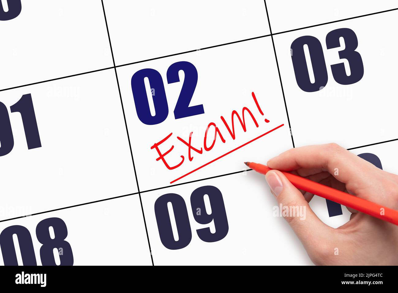 2nd day of the month. Hand writing text EXAM and drawing a line on ...
