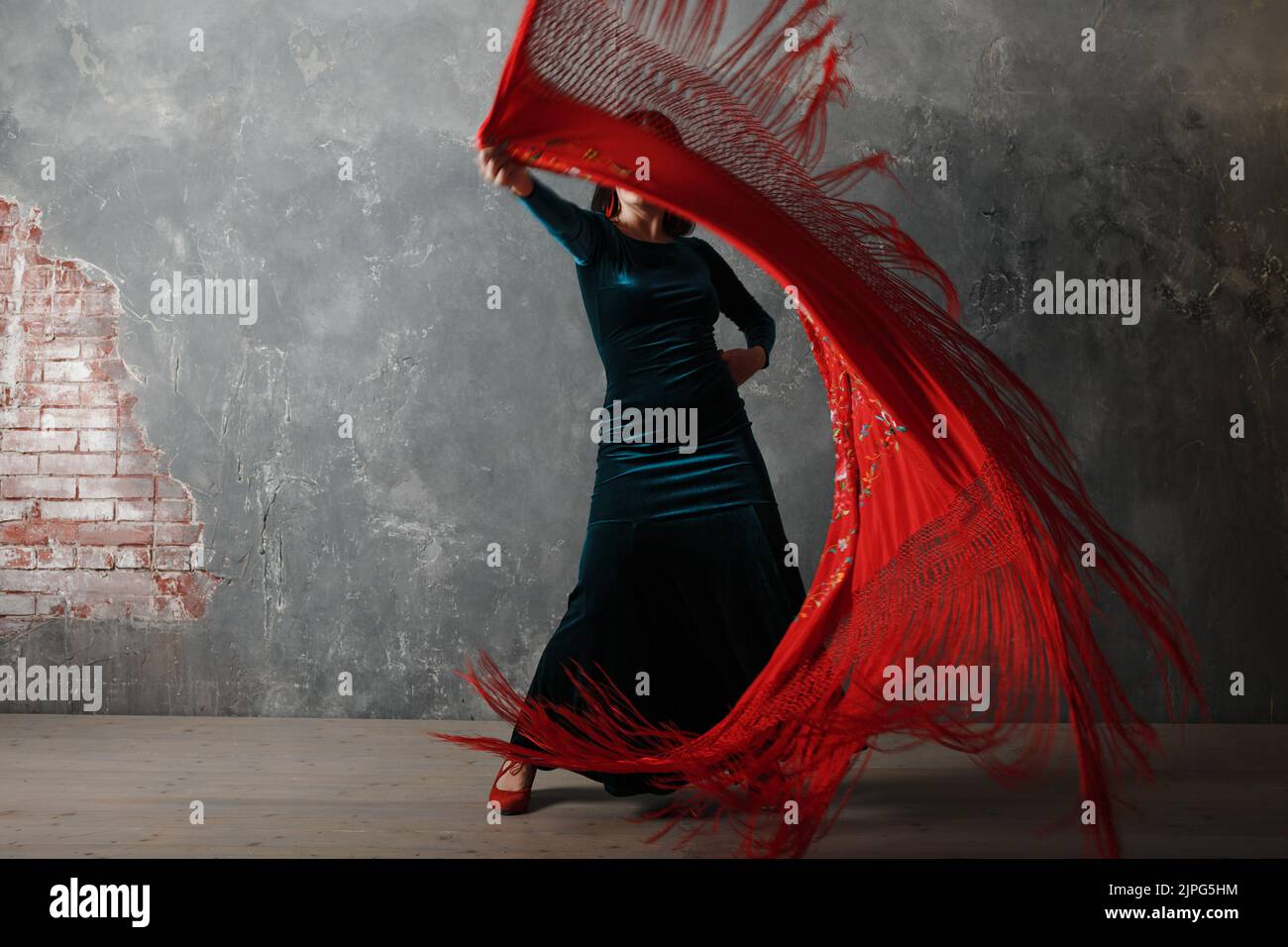Young adult spanish woman dancing flamenco on grey vintage studio ...