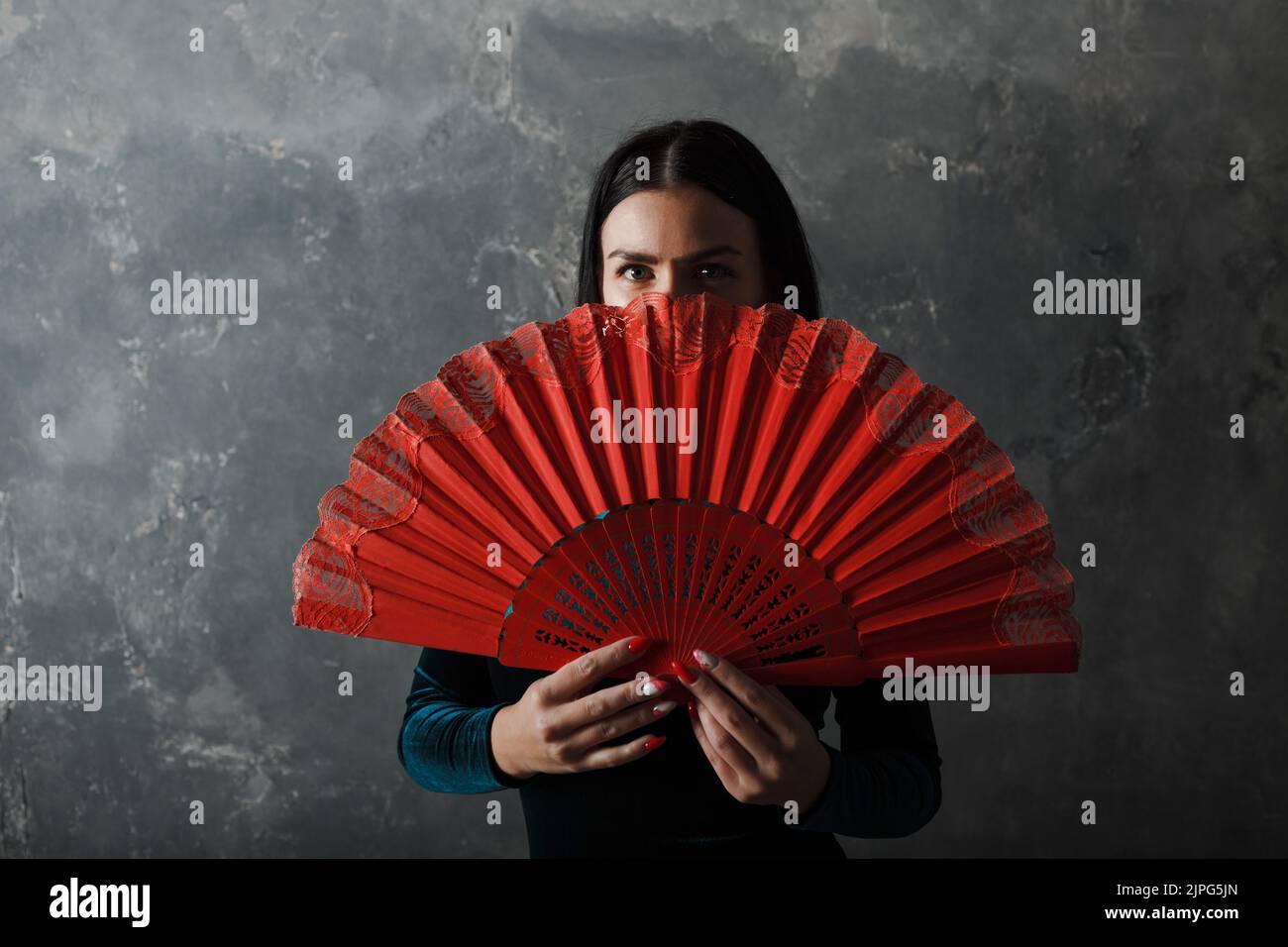 Young adult spanish woman dancing flamenco on grey vintage studio ...