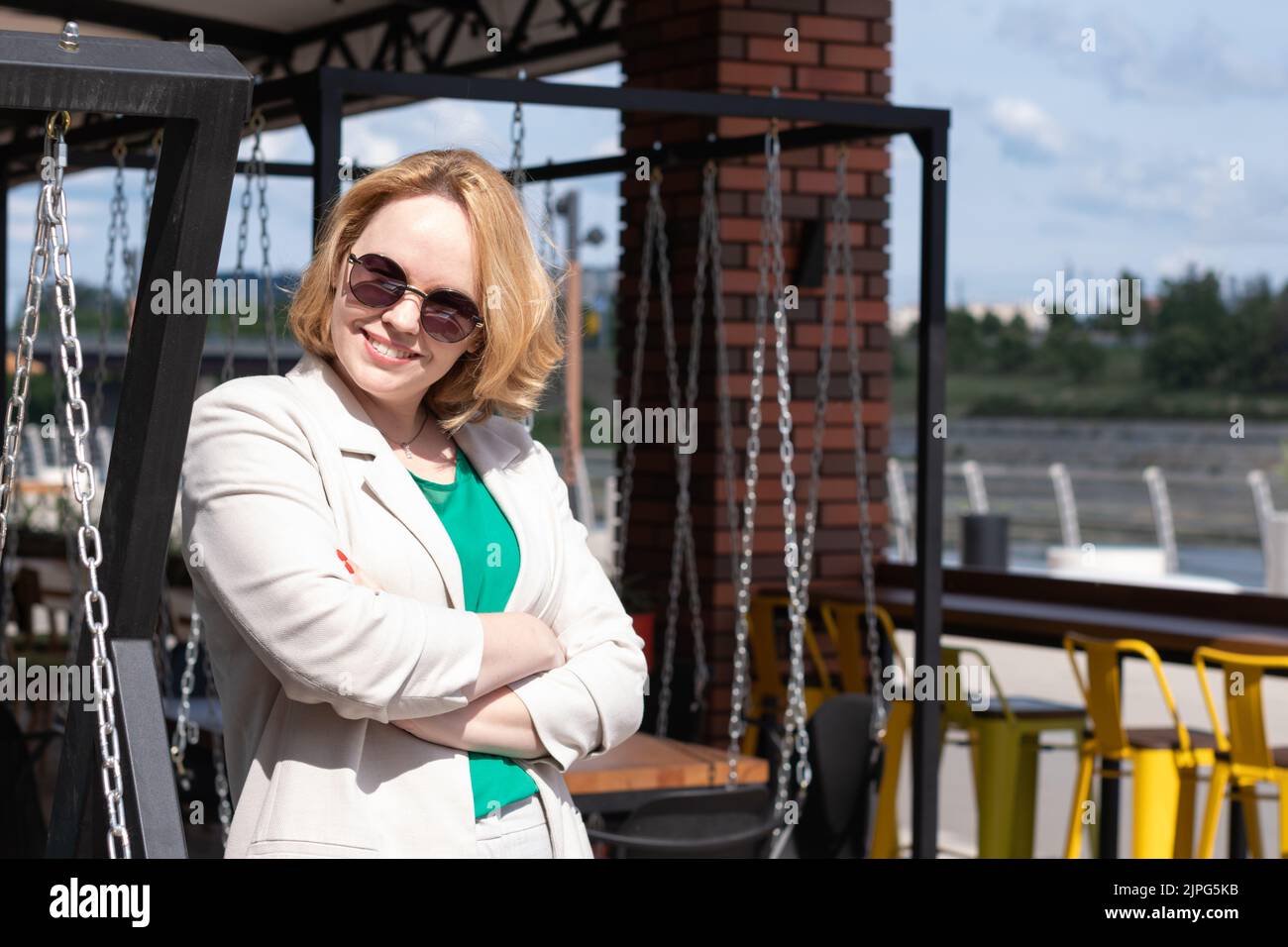 A confident trending middle-aged woman in a suit, holding her hands ...