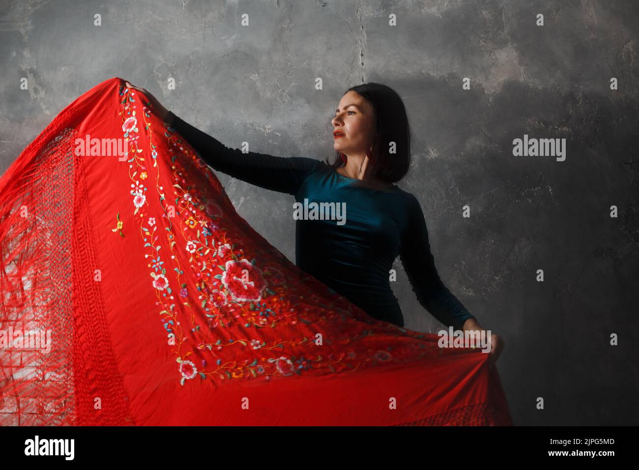 Young adult spanish woman dancing flamenco on gray vintage studio ...