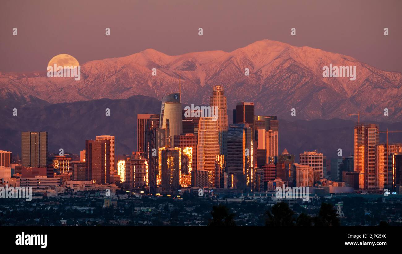 The full moon rising over the snow-capped San Gabriel Mountains in Los ...