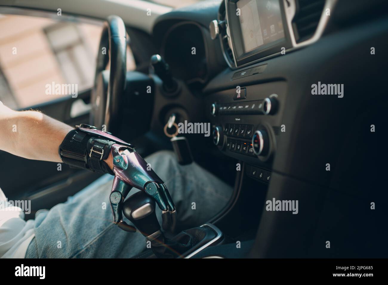 Young disabled man driver with artificial prosthetic hand driving ...