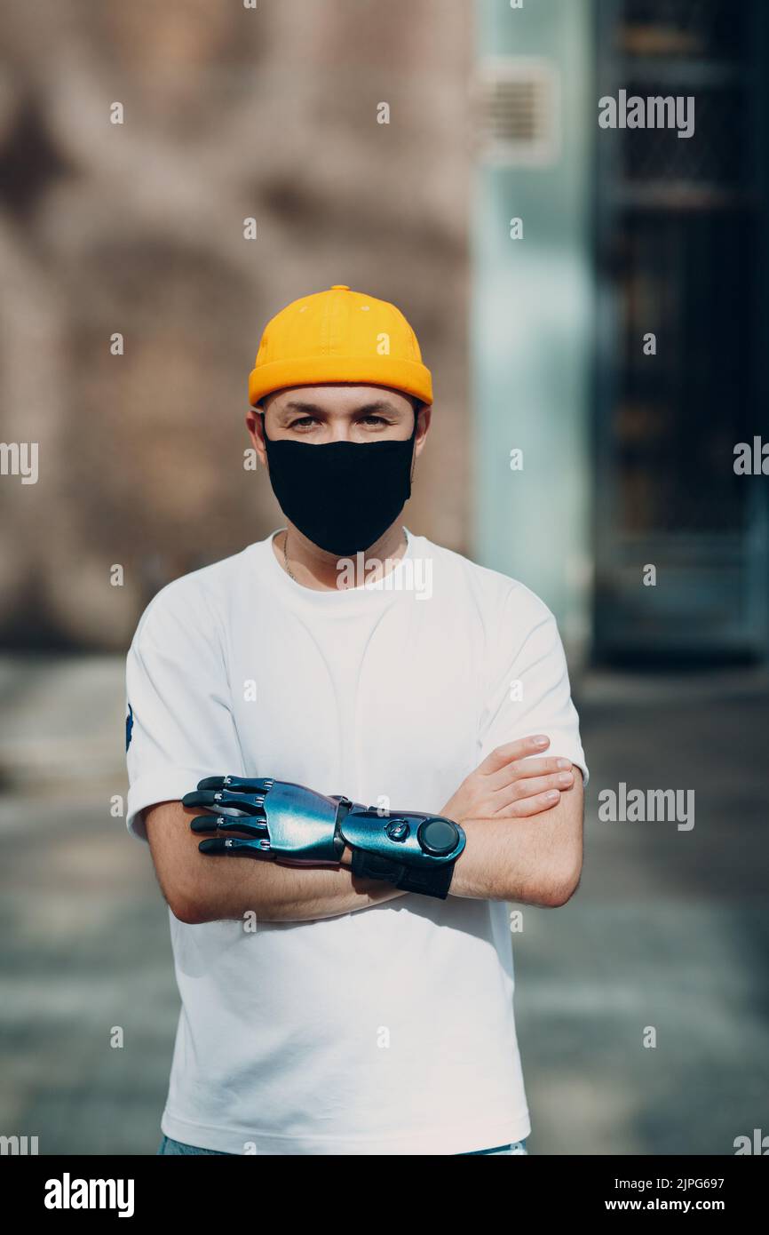 Young disabled man with artificial prosthetic hand wearing medical ...