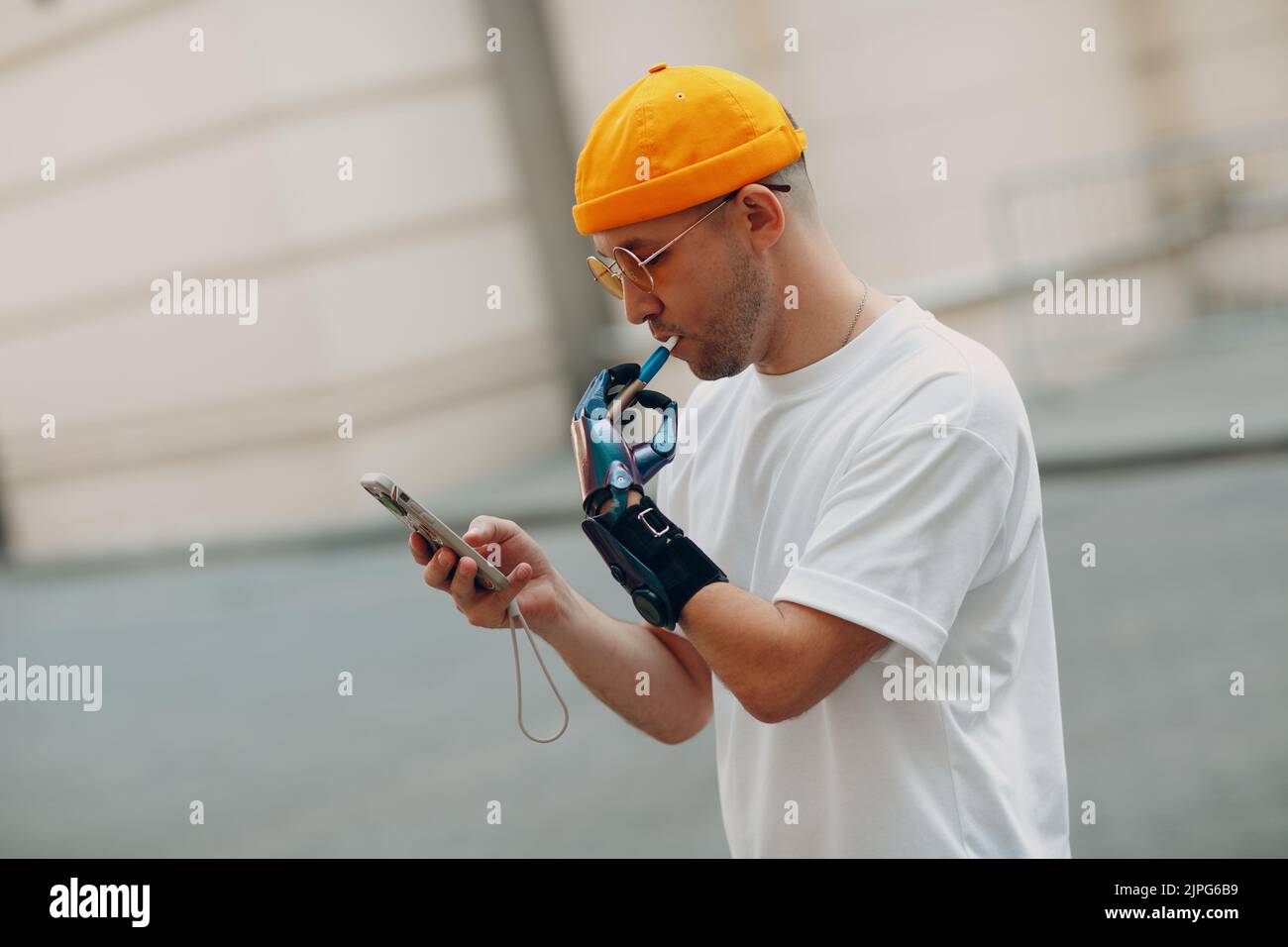 Young disabled man smoke electronic cigarette with artificial ...