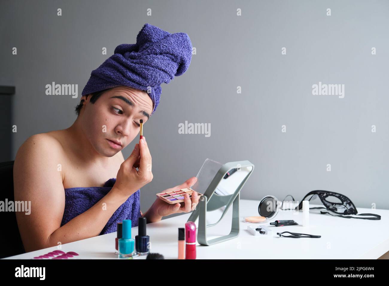 Young transgender man applying eyeshadow Stock Photo - Alamy