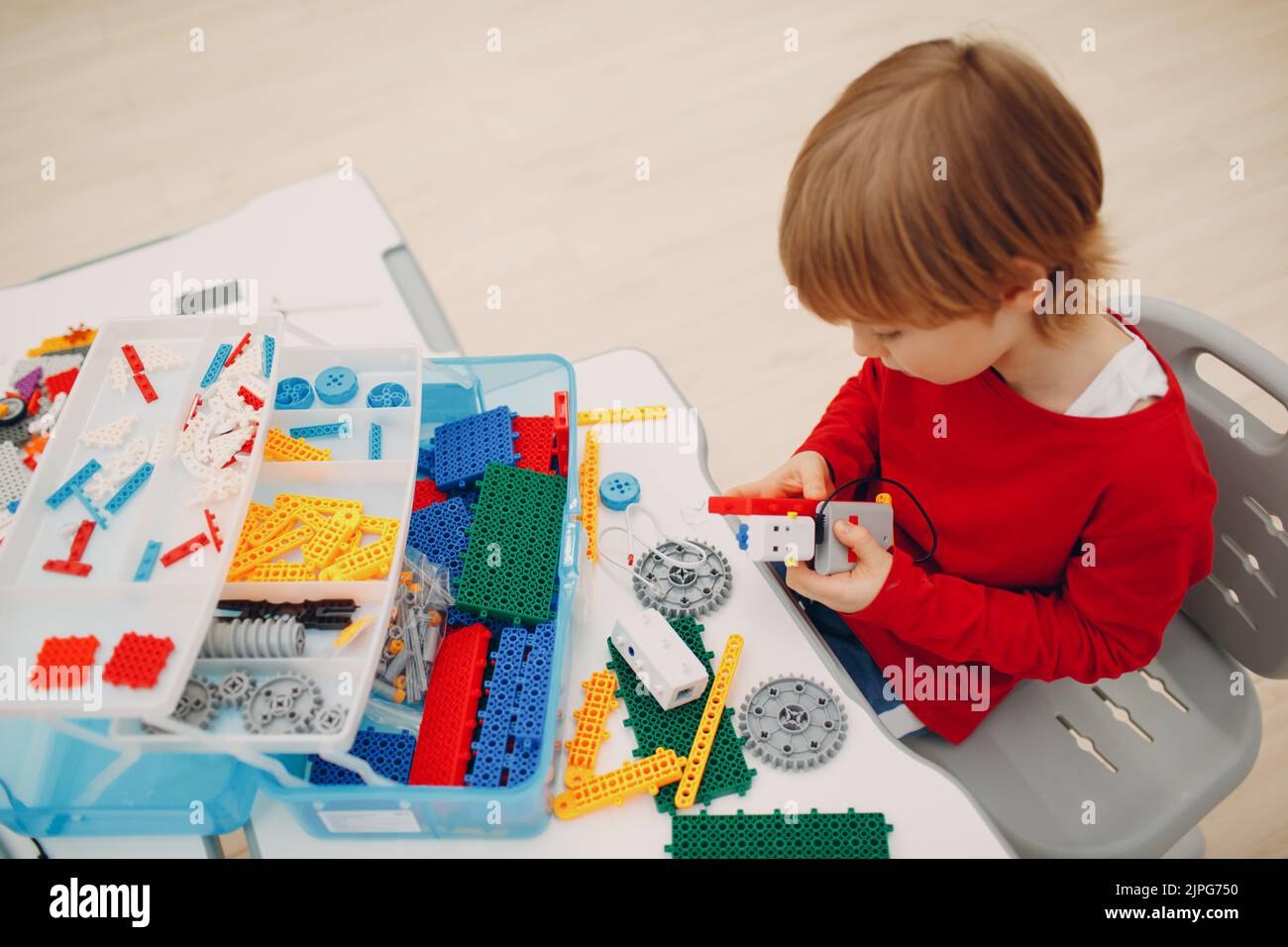 Smiling kid little boy child constructor checking technical toy ...