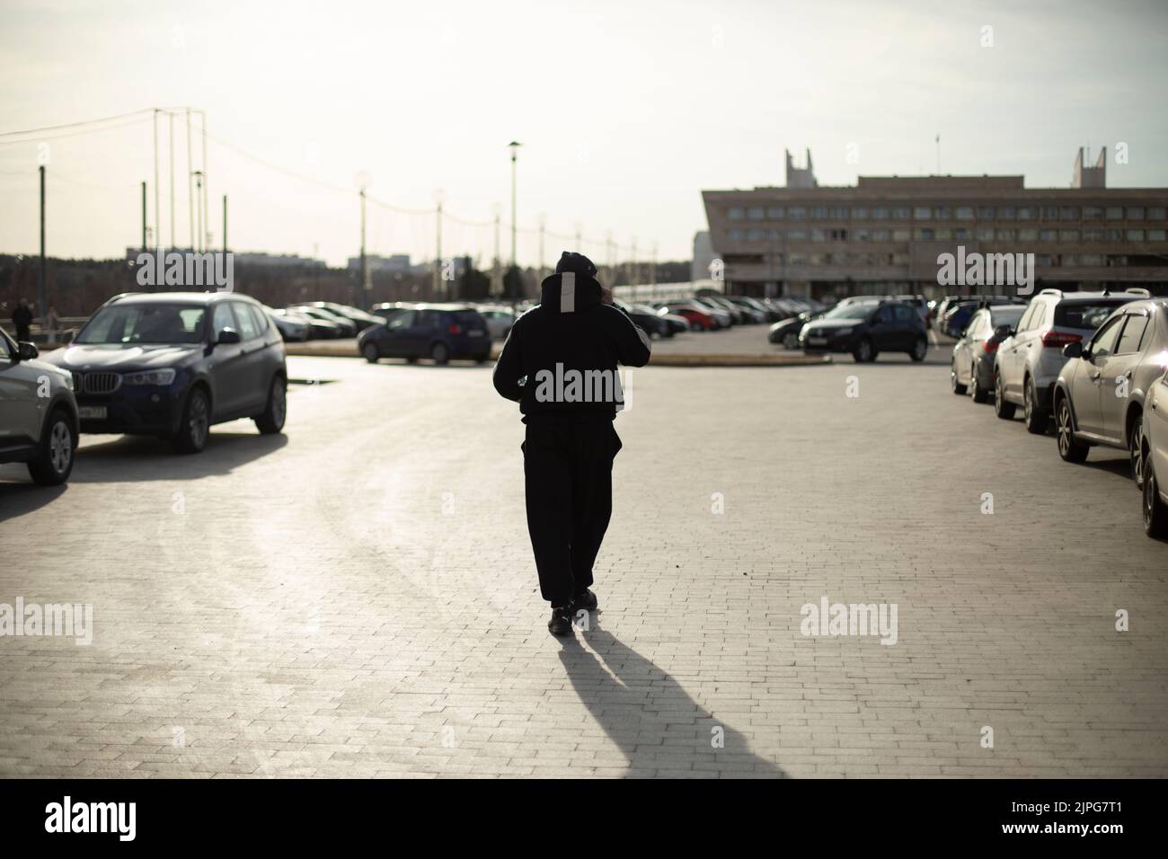 Man walks in parking lot. Man in town. Guy in square. Walk down street ...