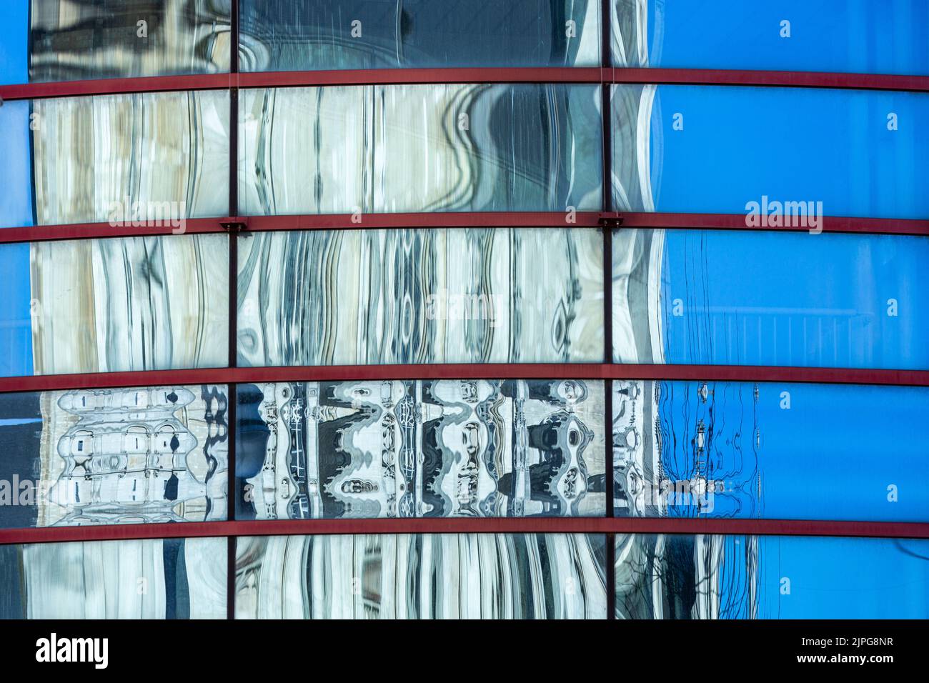 Distorted image of an ancient monument in the windows of a modern ...