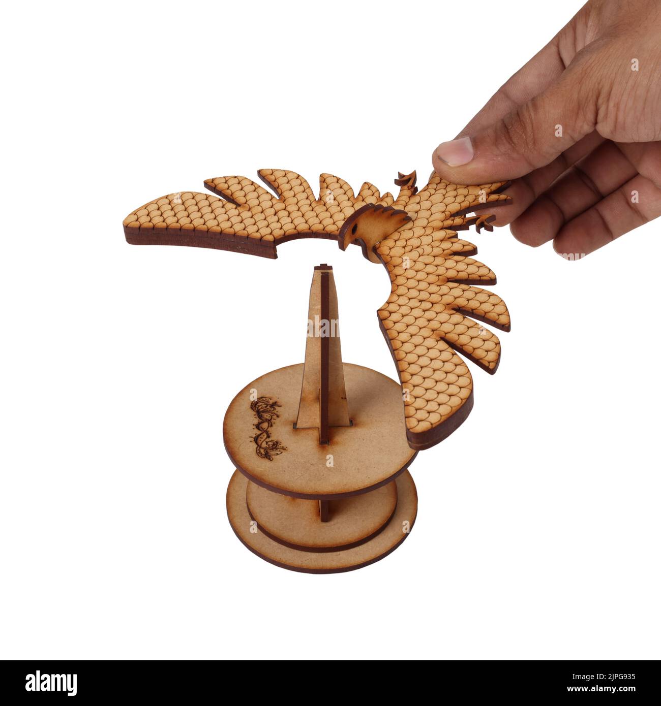 A human hand attaching wooden balancing bird to a stand Stock Photo - Alamy