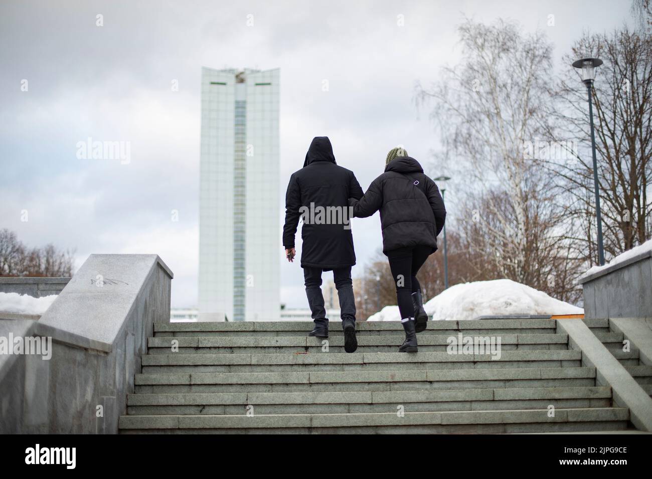 Guy and girl walk through city. Man leads girl under his arm. People on ...