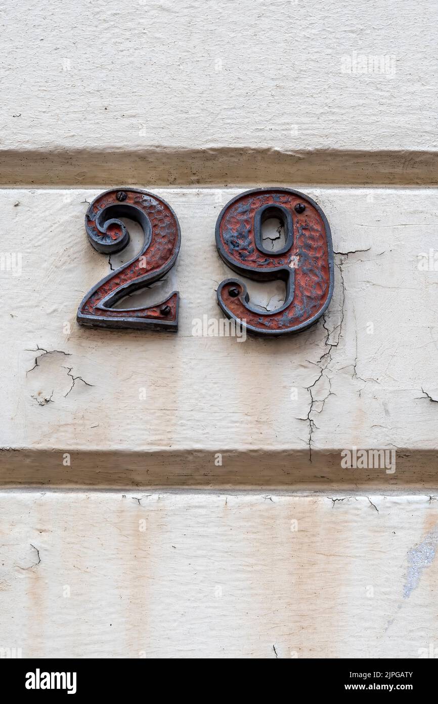 Number twenty nine on white painted plaster wall Stock Photo - Alamy