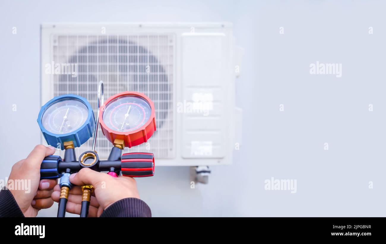 Air repair mechanic using measuring equipment for filling industrial ...