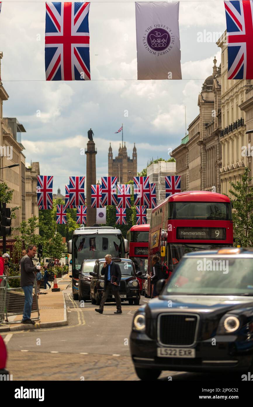 A vertical shot of British flags hanging on the street before the Queen ...