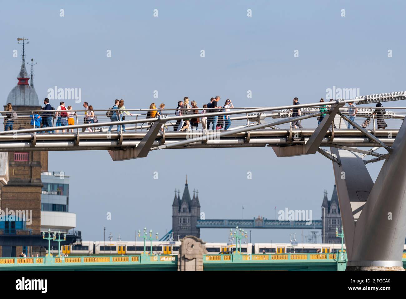 People walking across the Millennium Bridge over the River Thames ...