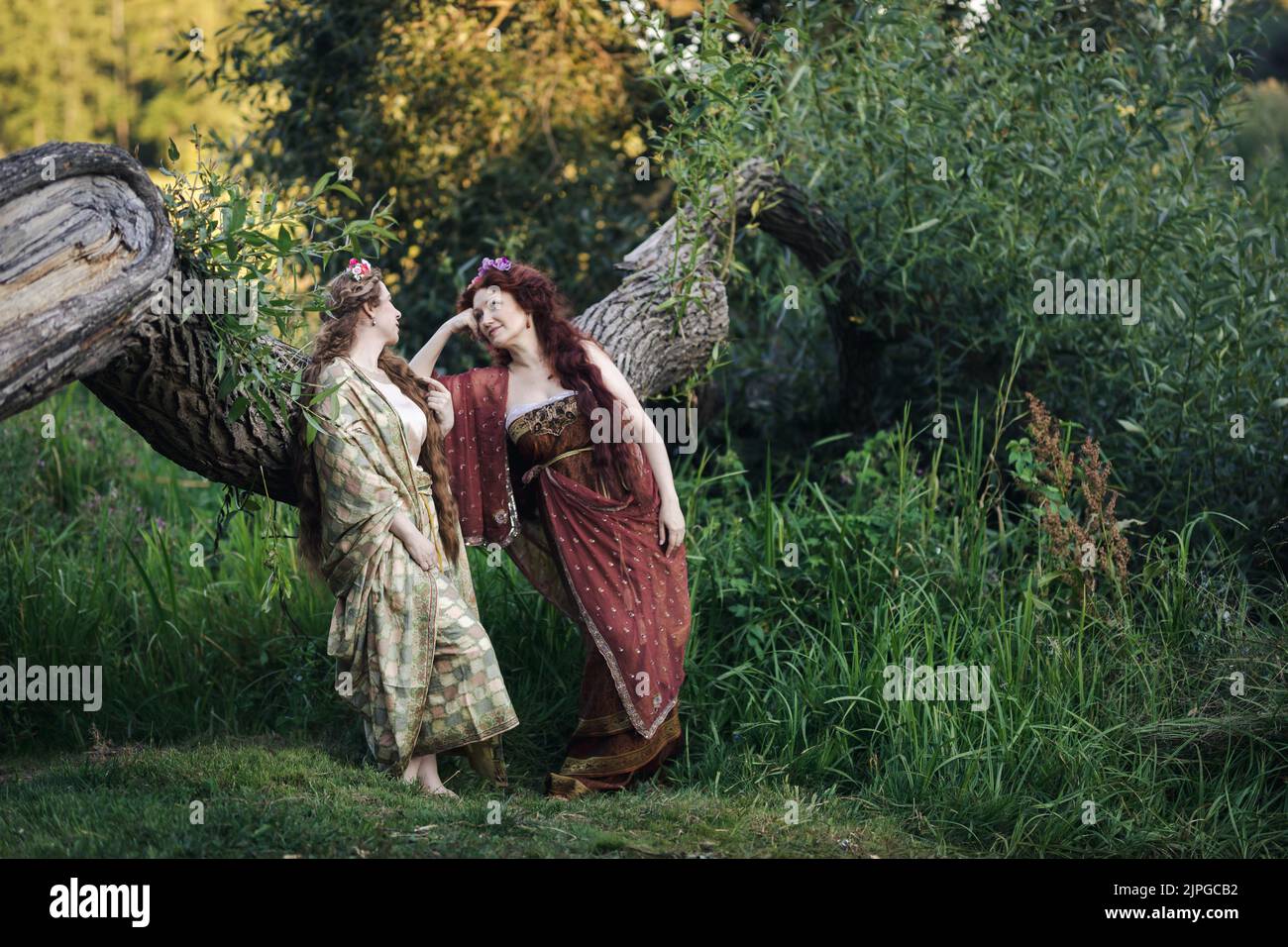 Portrait of two beautiful mature women dressed in a nymph-style dress ...