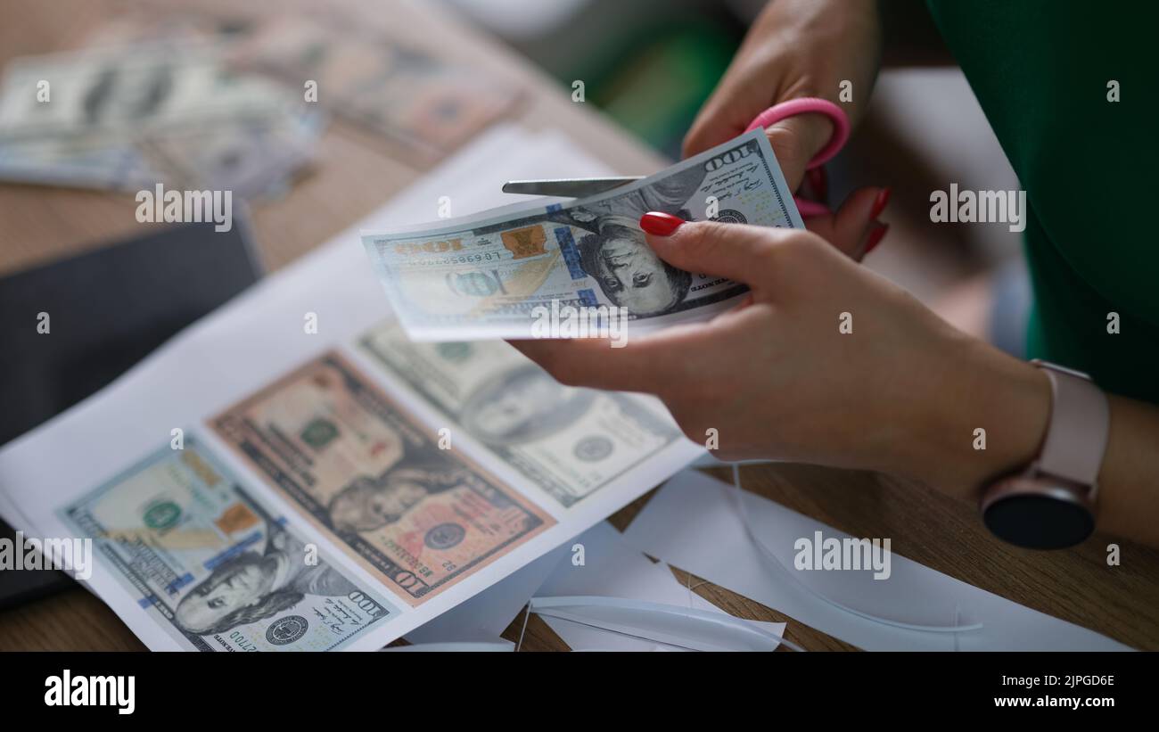 Female hand cuts counterfeit money American dollars Stock Photo - Alamy