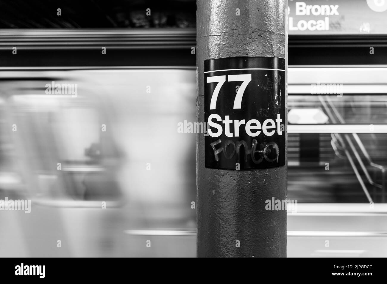 A grayscale shot of a signboard of 77 street on a pipe Stock Photo - Alamy