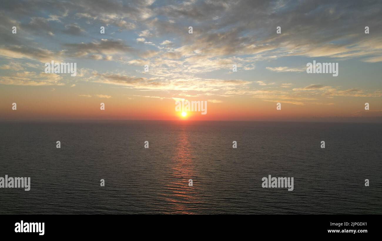 The sun rising over the water Stock Photo - Alamy