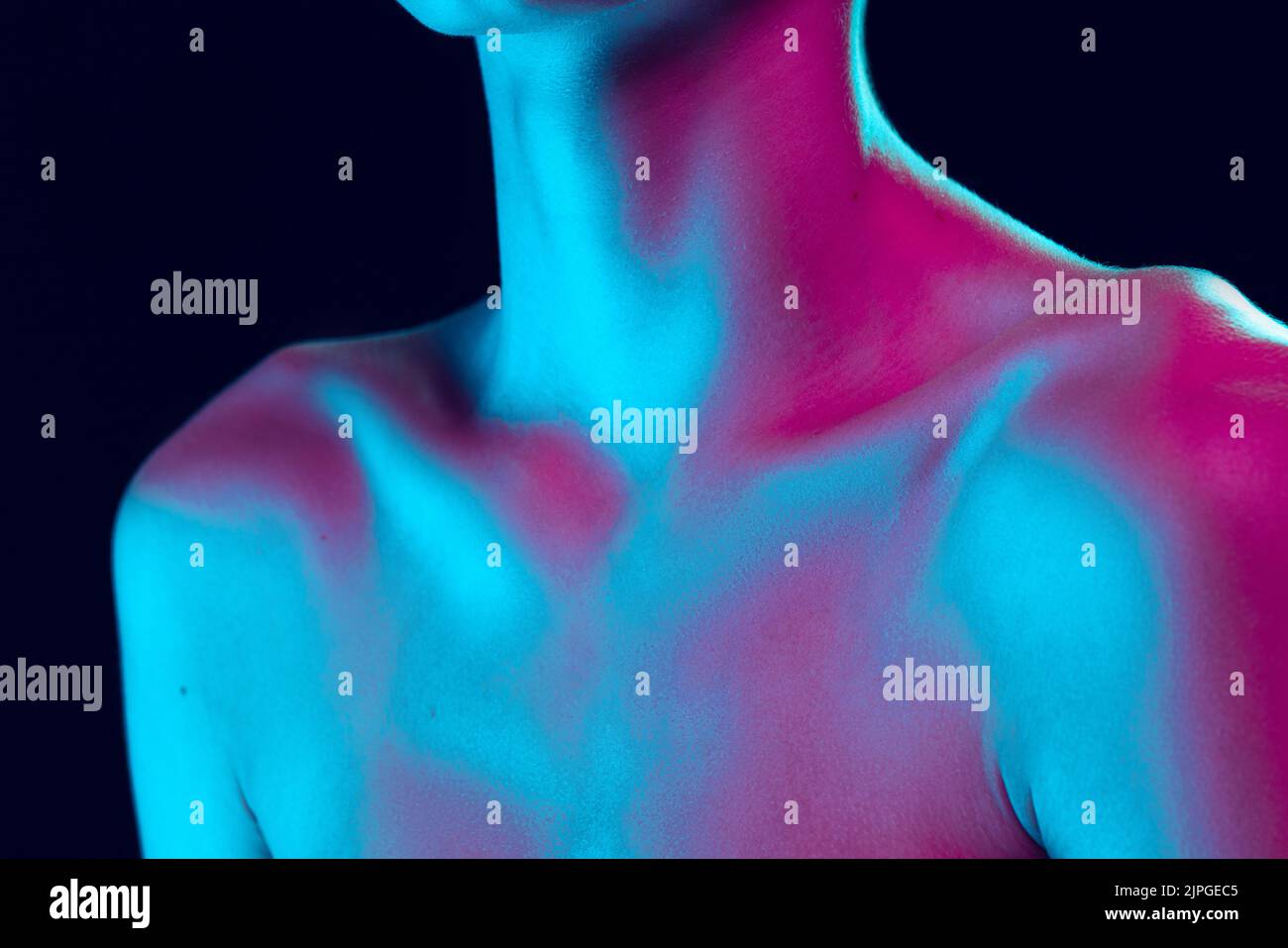 Close up female neck, collarbones and shoulders in pink neon light over ...