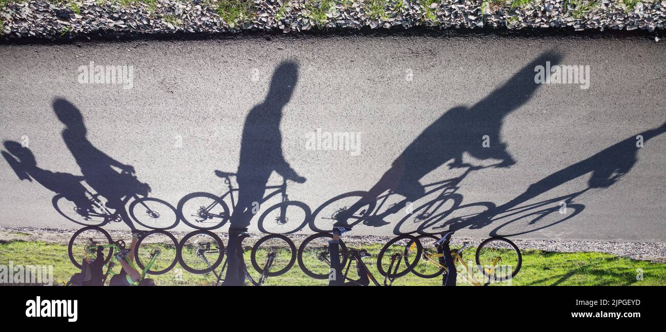 inverted image of several cyclists standing on the pavement ...