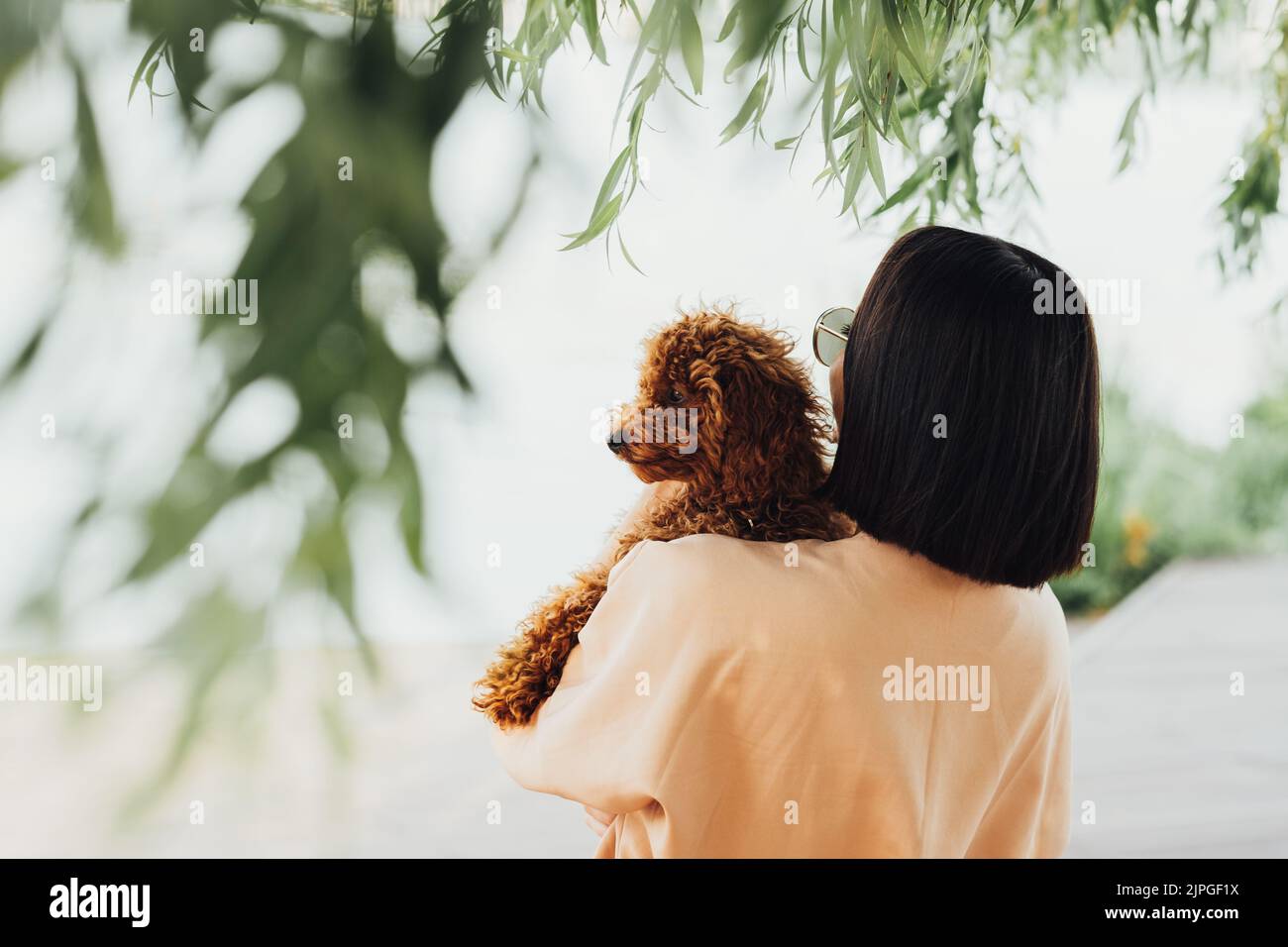 Young brunette woman holding on hands and hugging her little redhead ...