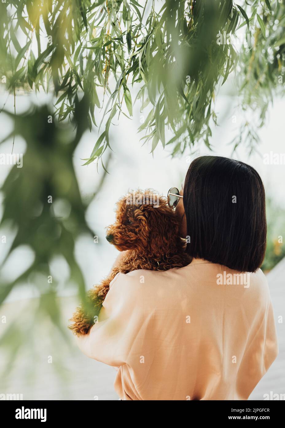 Young brunette woman holding on hands and hugging her little redhead ...