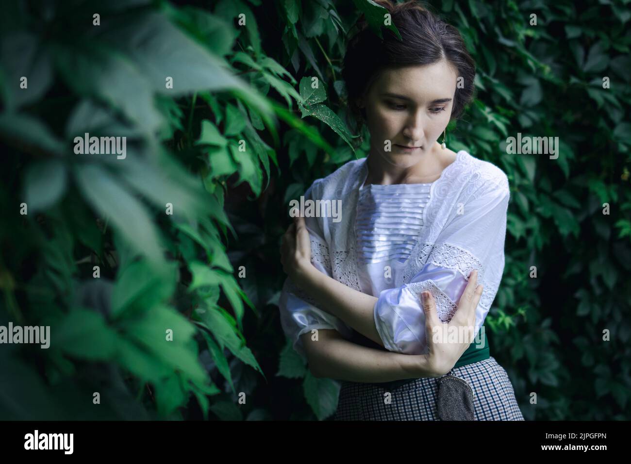 Portrait of a young slender woman in a 1910s costume. Lady near a ...