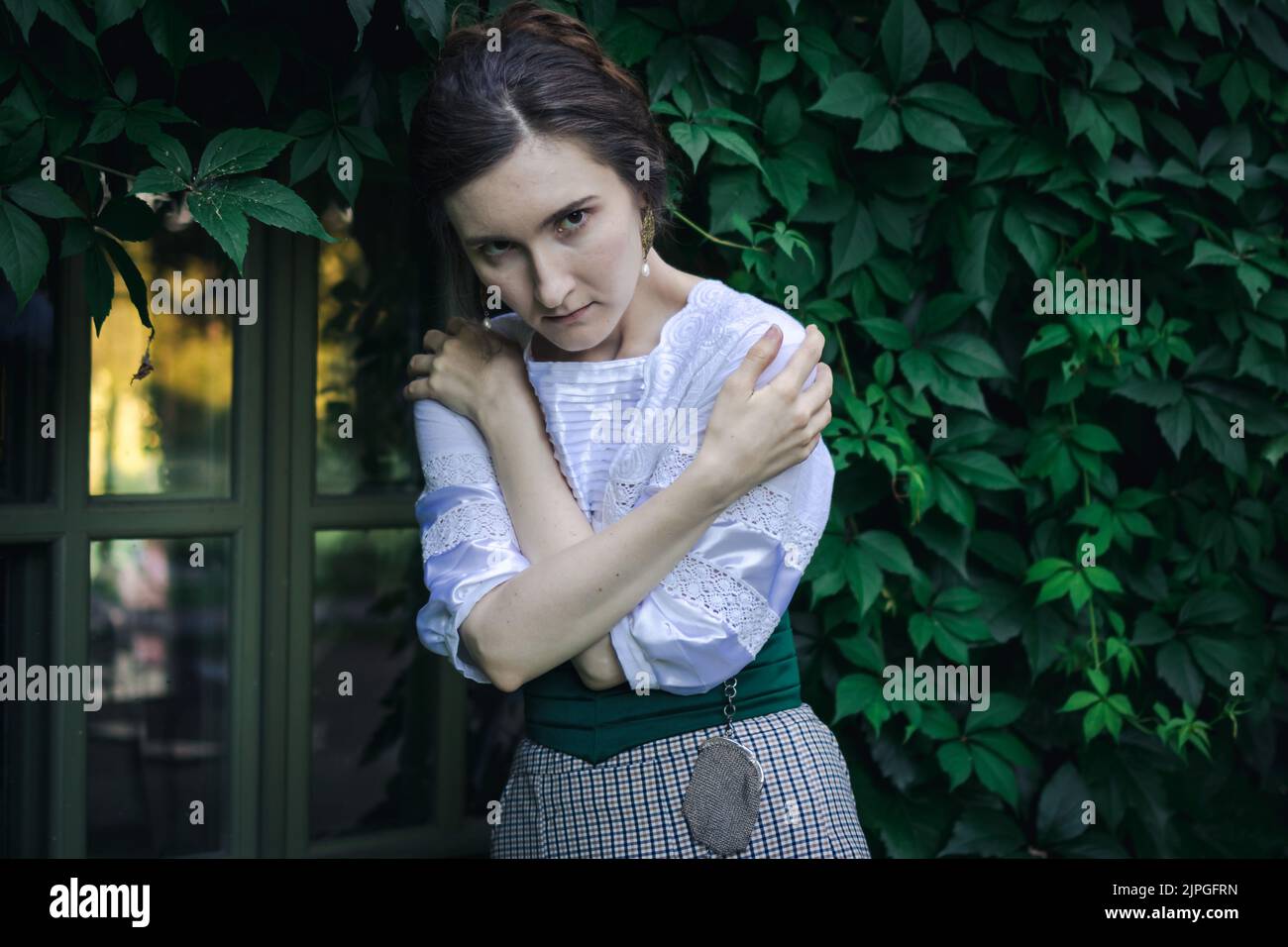 Portrait of a young slender woman in a 1910s costume. Lady near a ...