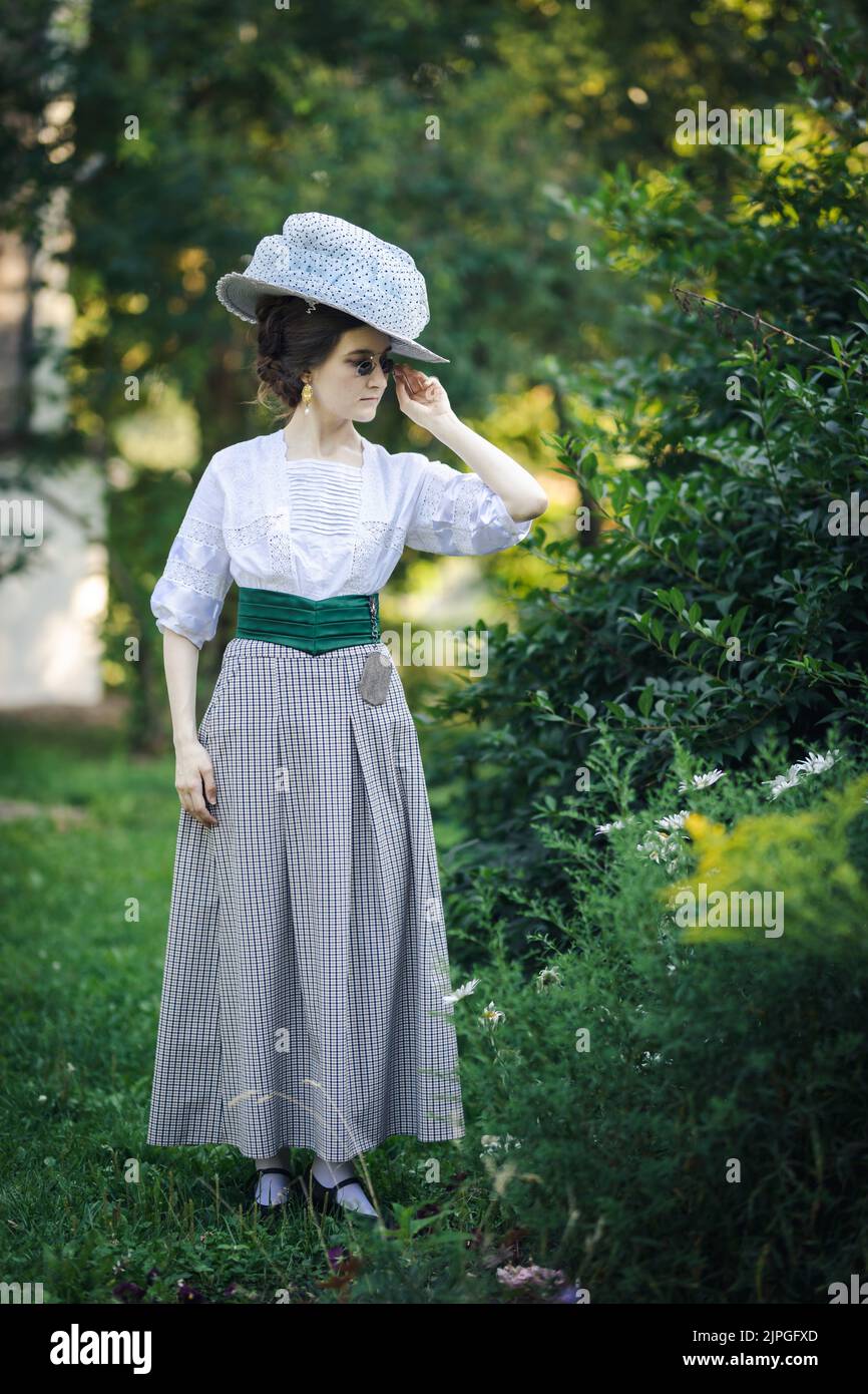 Portrait of a young slender woman in a 1910s costume. A lady in a hat ...