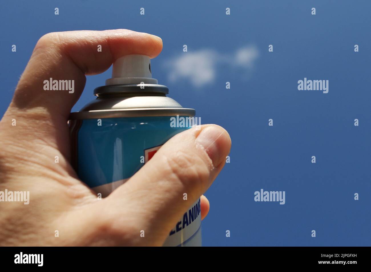 Abstract painting. Man painting with spray clouds on sky background ...