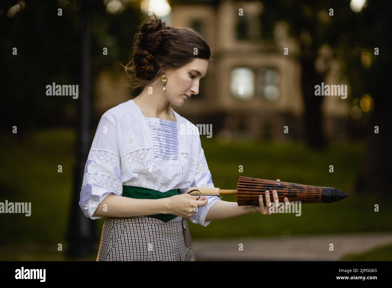 Portrait of a young slender woman in a 1910s costume. Lady walking in ...