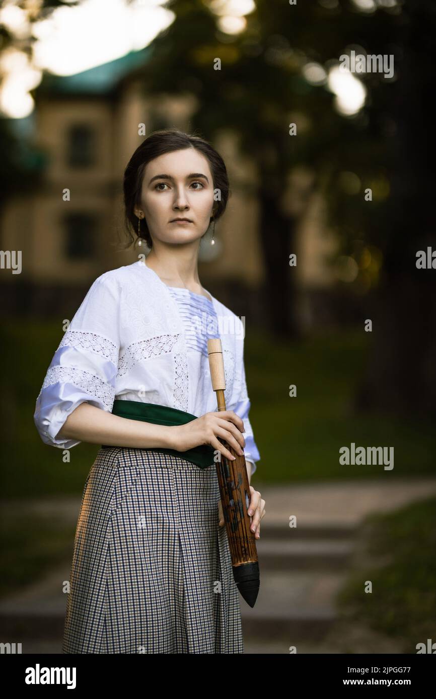 Portrait of a young slender woman in a 1910s costume. Lady walking in ...
