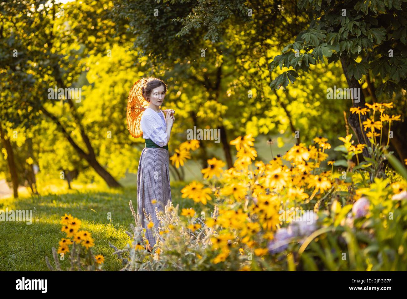 Portrait of a young slender woman in a 1910s costume. Lady walking in ...