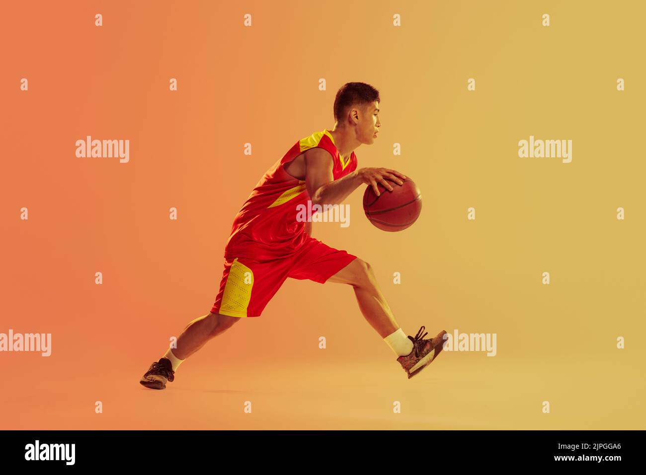 Dynamic portrait of young man, basketball player in motion, dribbling ...