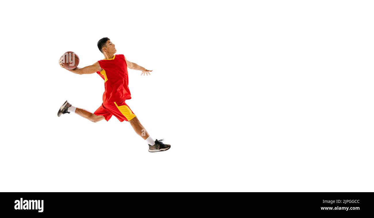 Portrait of young man, basketball player throwing ball into basket in a ...