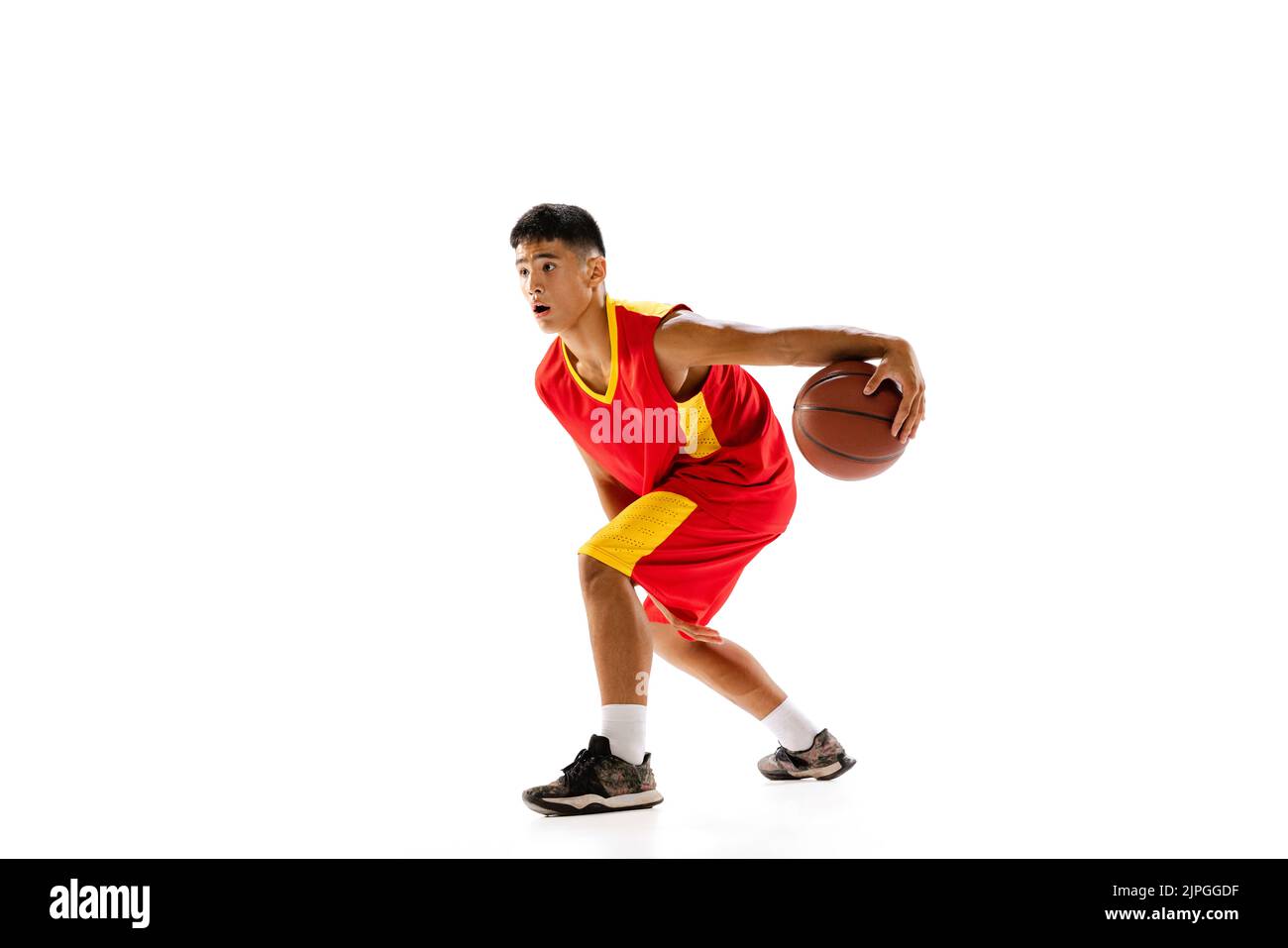 Portrait of young man, basketball player in red uniform training ...