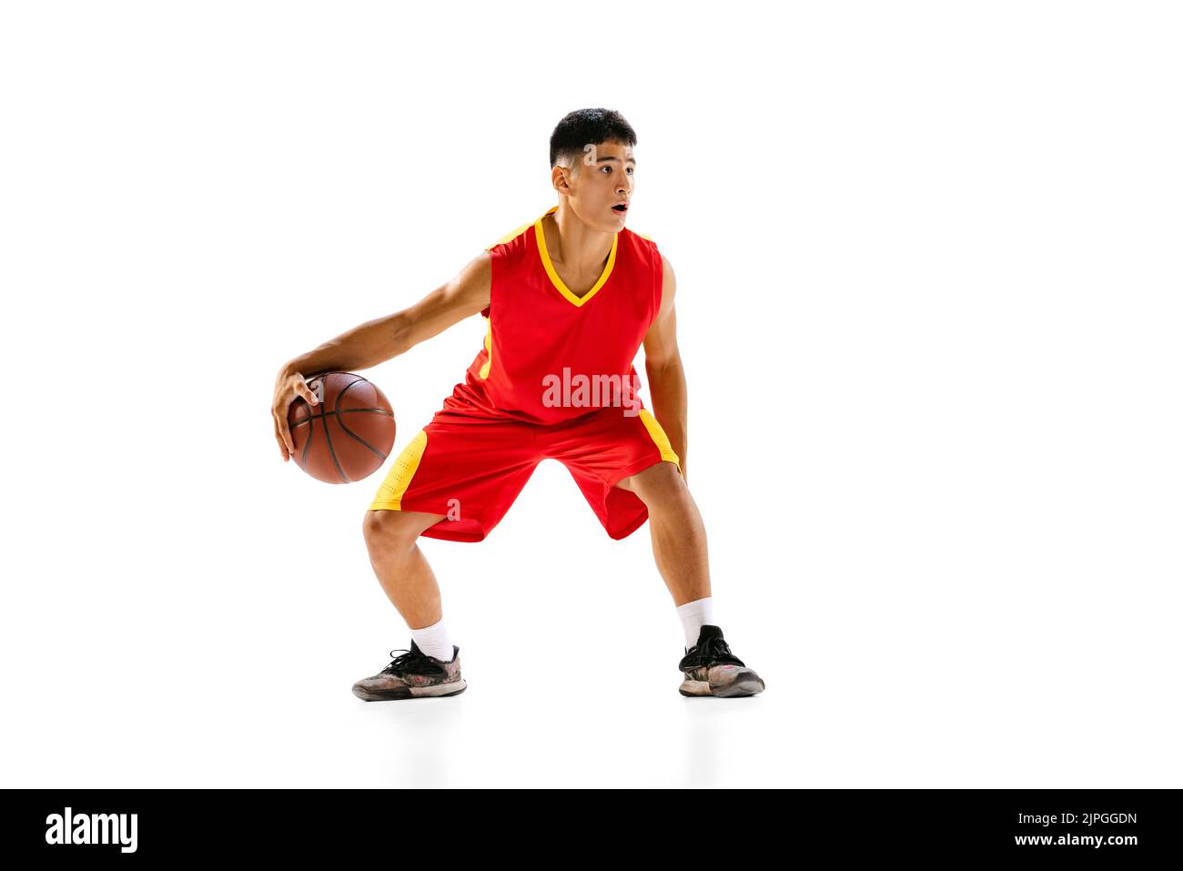 Portrait of young motivated man, basketball player training, dribbling ...