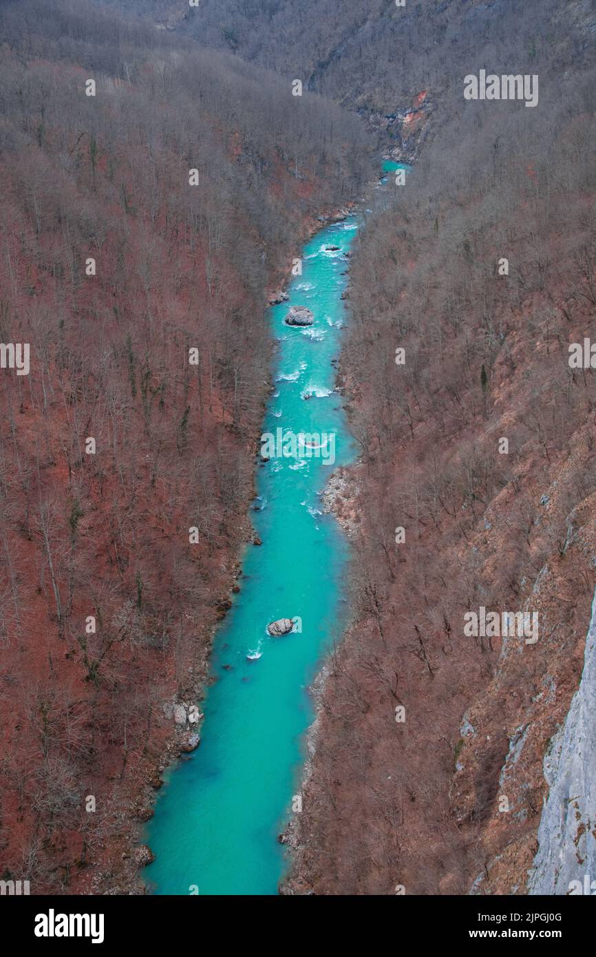 A very aqua blue river running trough red dirt covered mountainous ...