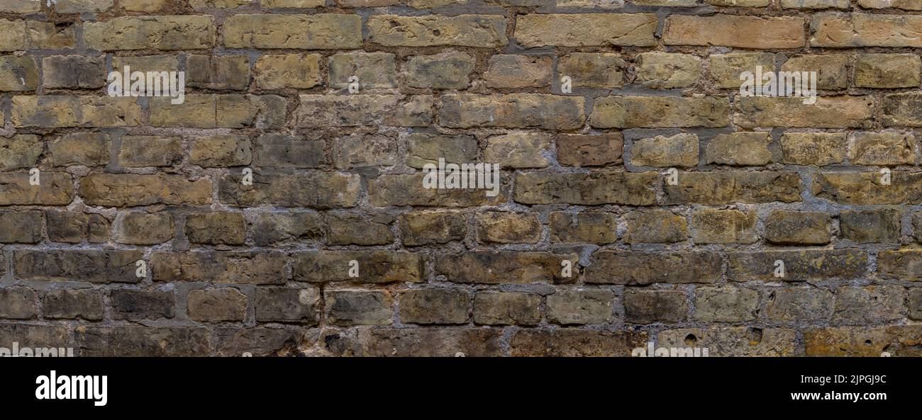 Wide weathered beige brown brick wall background Stock Photo - Alamy