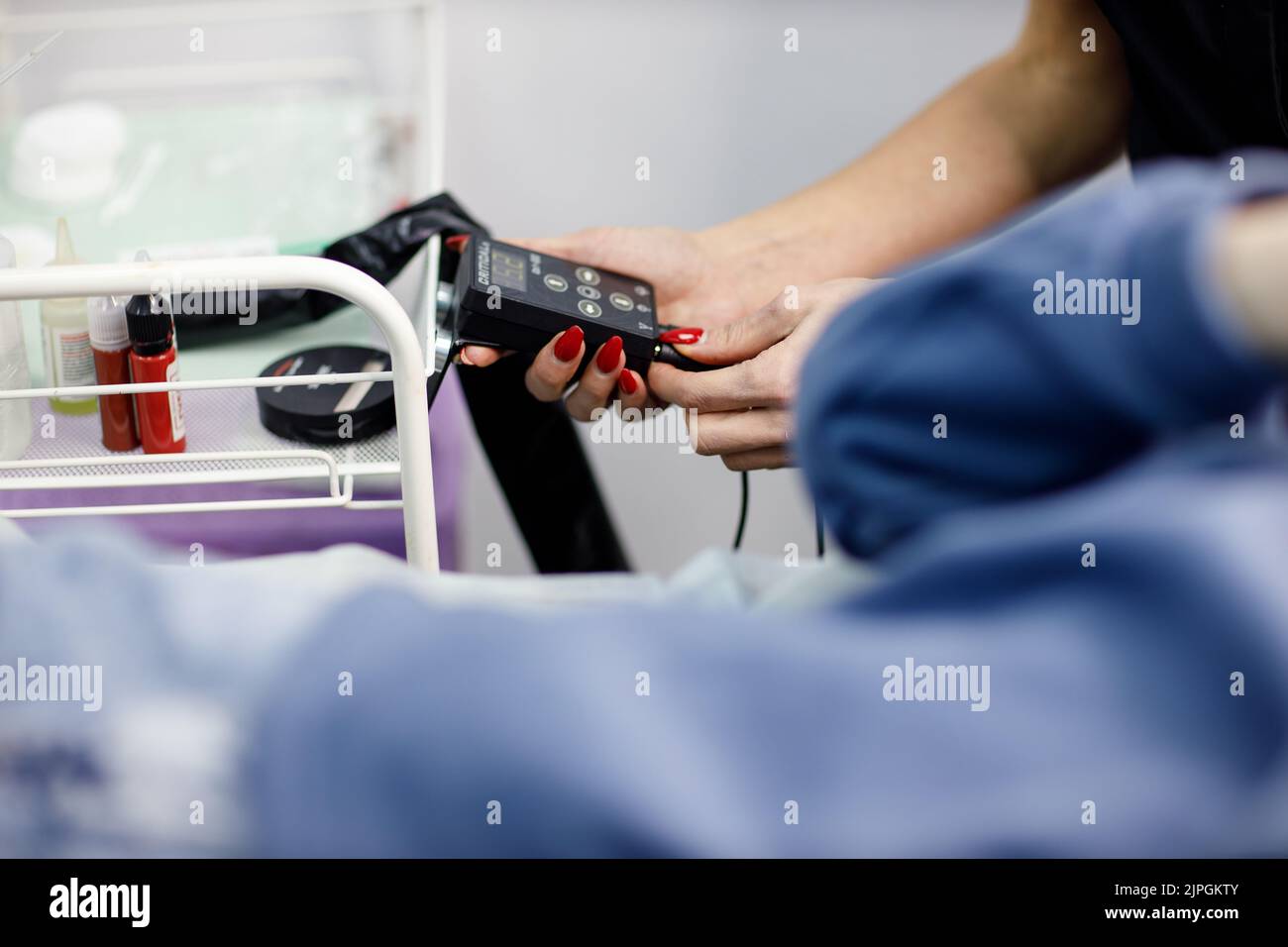 Permanent lip tattoo needle machine pumping equipment on table on salon ...