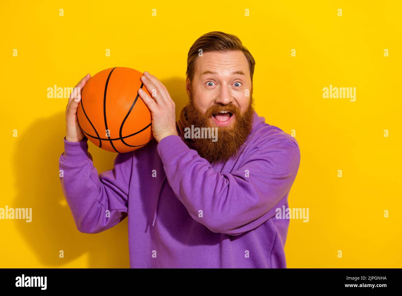 Photo of sweet impressed man wear violet sweatshirt catching basketball ...