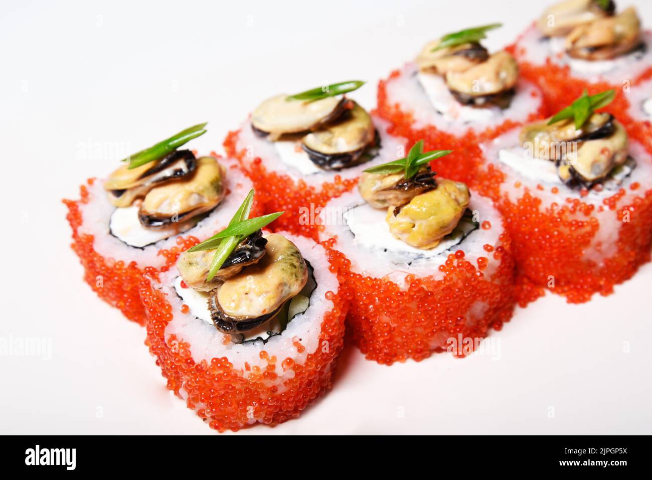 Elite sushi on a white background in red tobiko caviar with mussels on ...